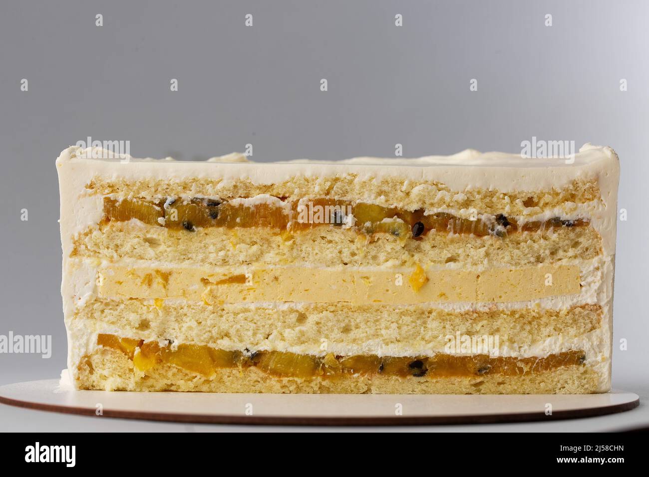 On a white background, a sweet pastry cake is cut in half, the cake is ...