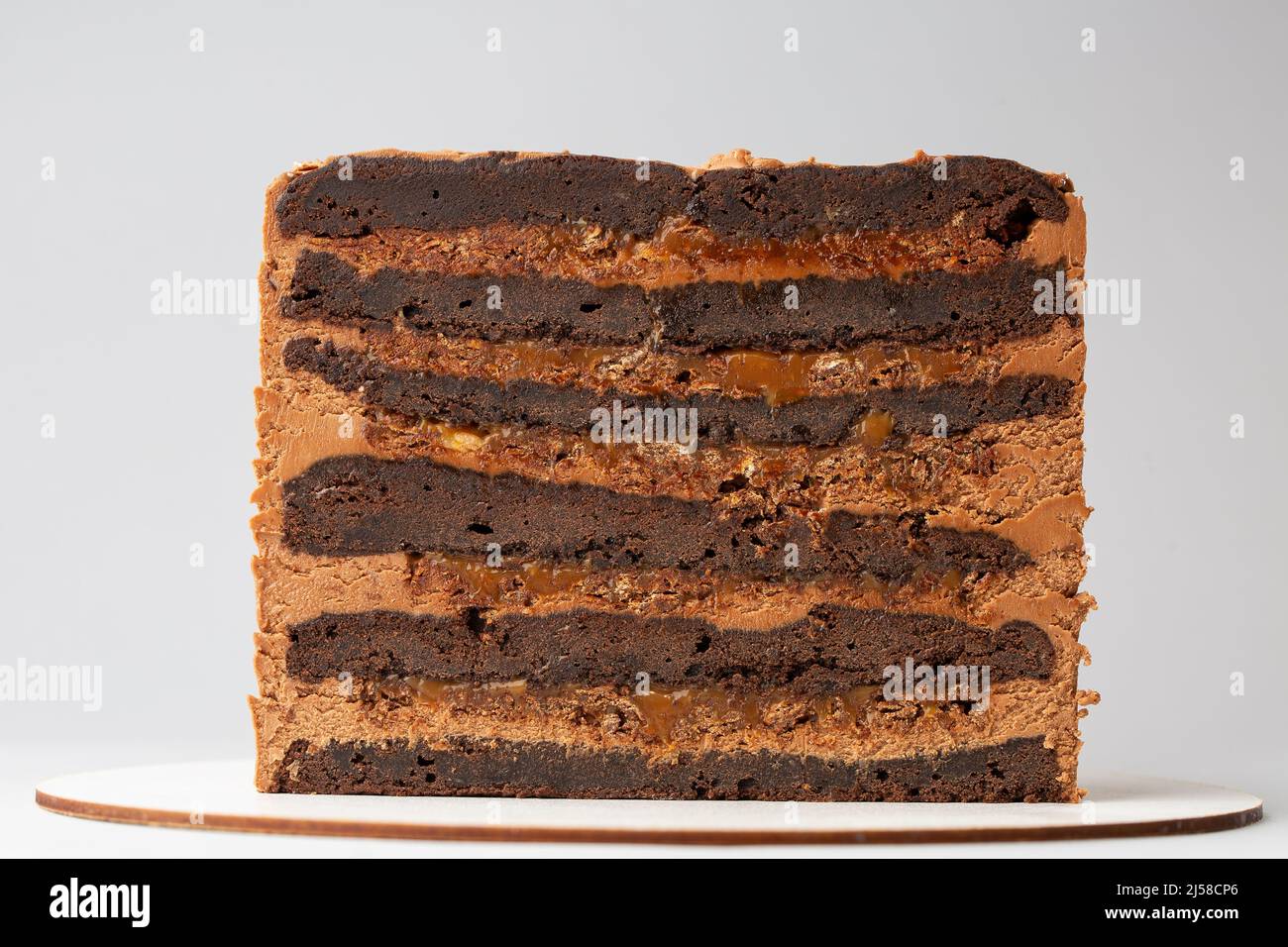 On a white background, a sweet pastry cake is cut in half, the cake is ...