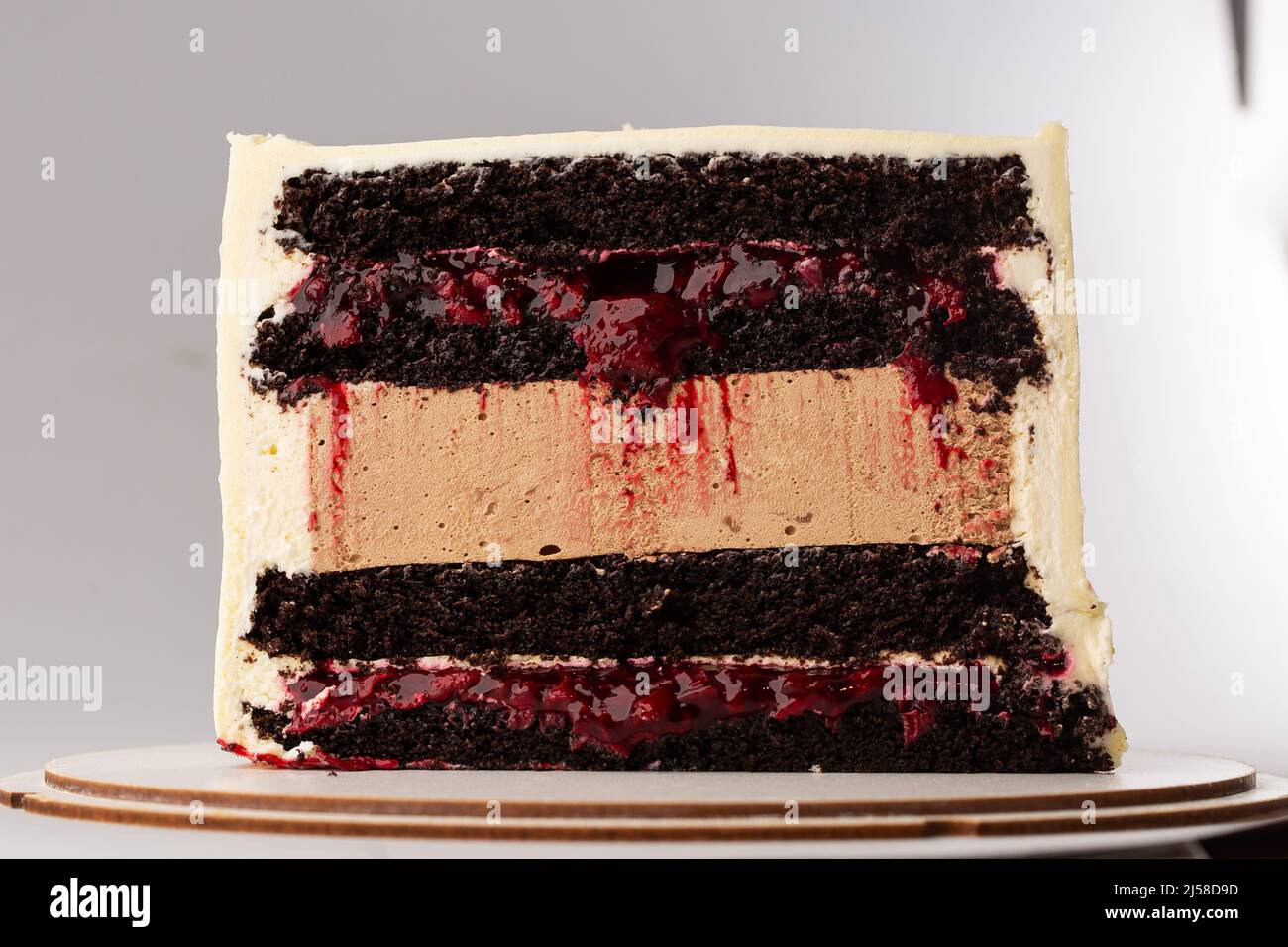 On a white background, a sweet pastry cake is cut in half, the cake is ...