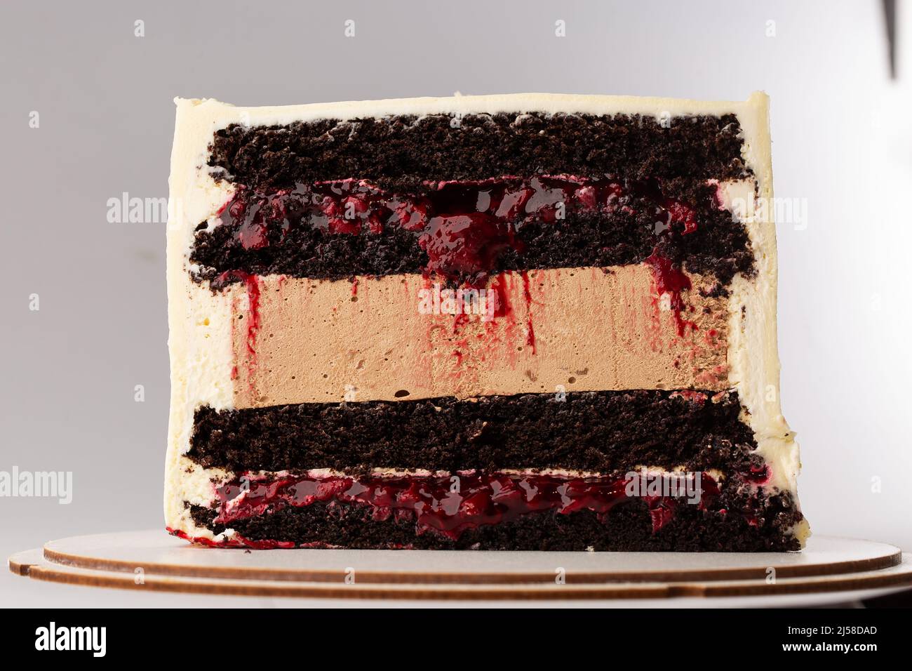 On a white background, a sweet pastry cake is cut in half, the cake is ...