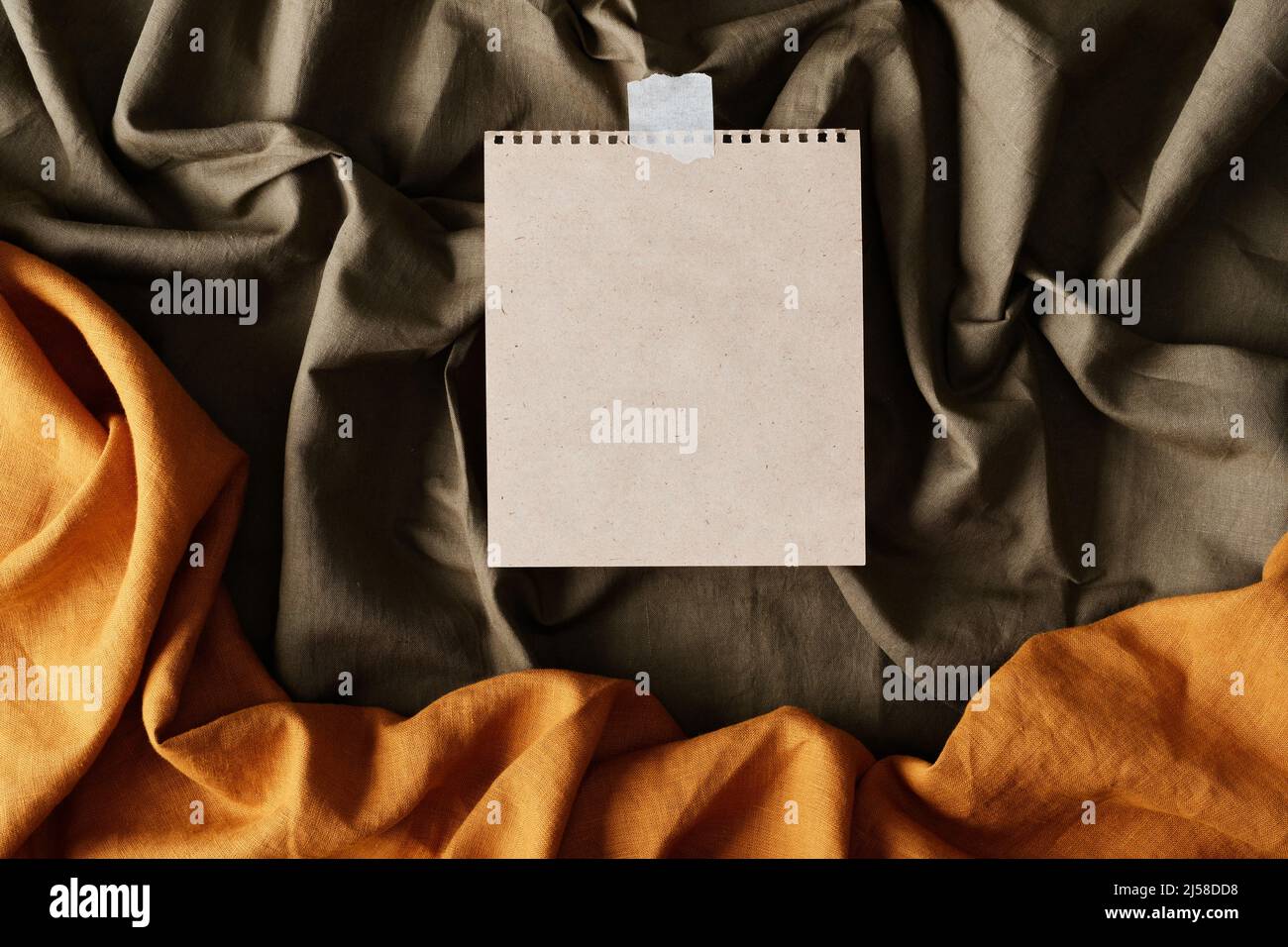 Blank sheet of paper attached to wrinkled gray fabric, note concept ...