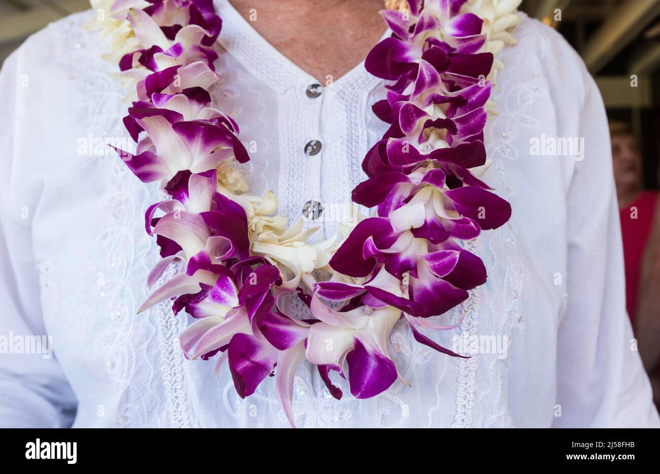 A woman visitor wears a traditional Hawaiin flower lei made of orchids ...