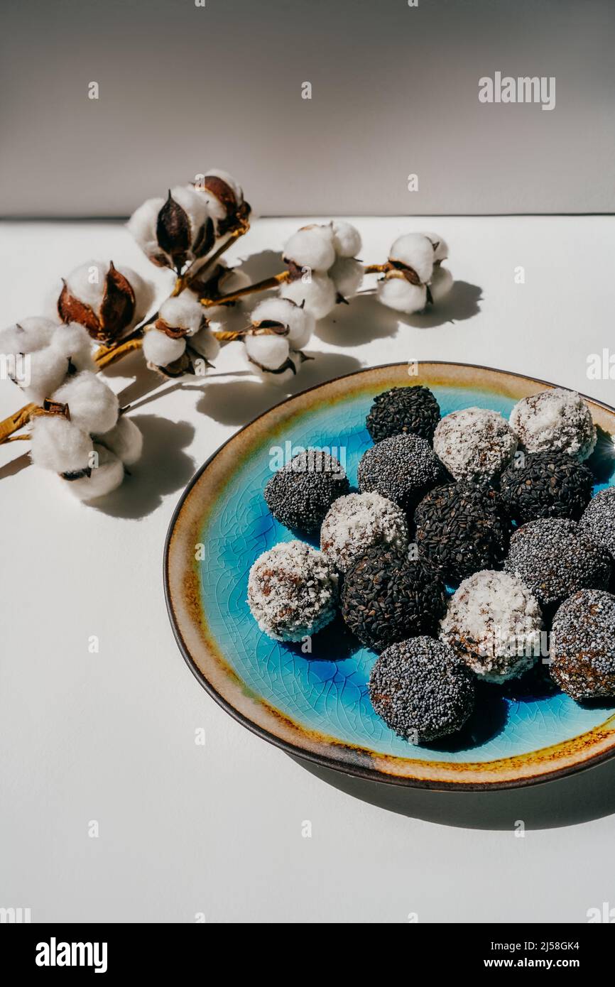 Homemade date candies covered with poppy, sesame and shredded coconut ...