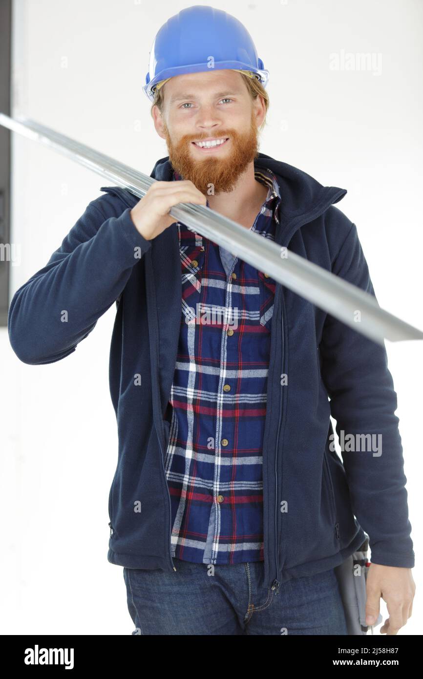 happy builder carrying sheet of metal Stock Photo - Alamy