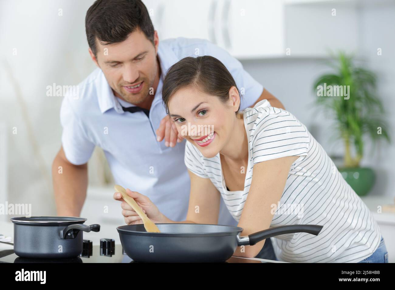 cute couple cooking together in kitchen Stock Photo - Alamy