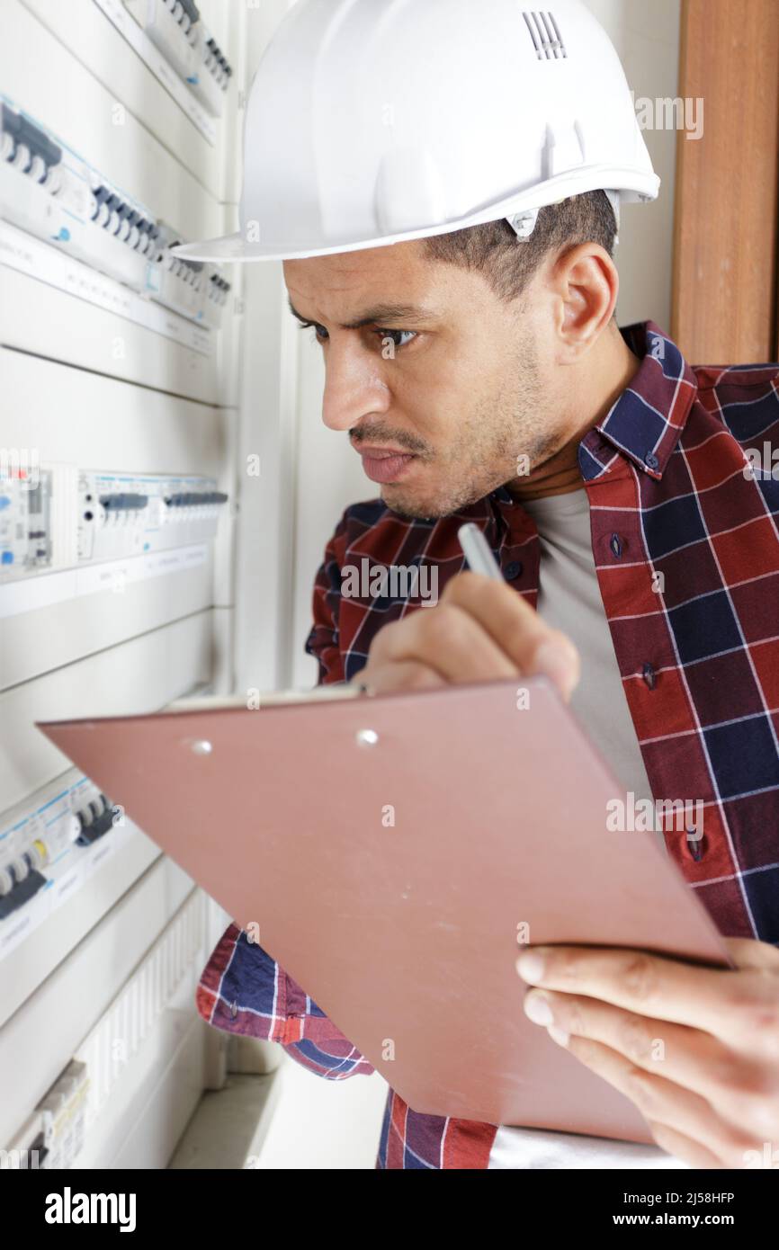 engineer electrician with clipboard in electrical control box Stock ...