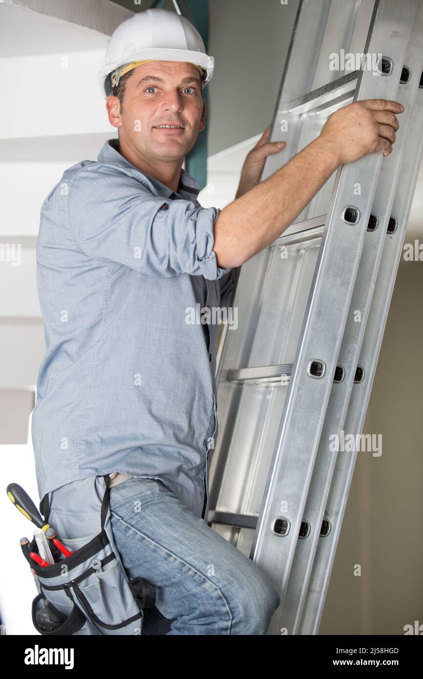 young man in uniform with ladder Stock Photo - Alamy