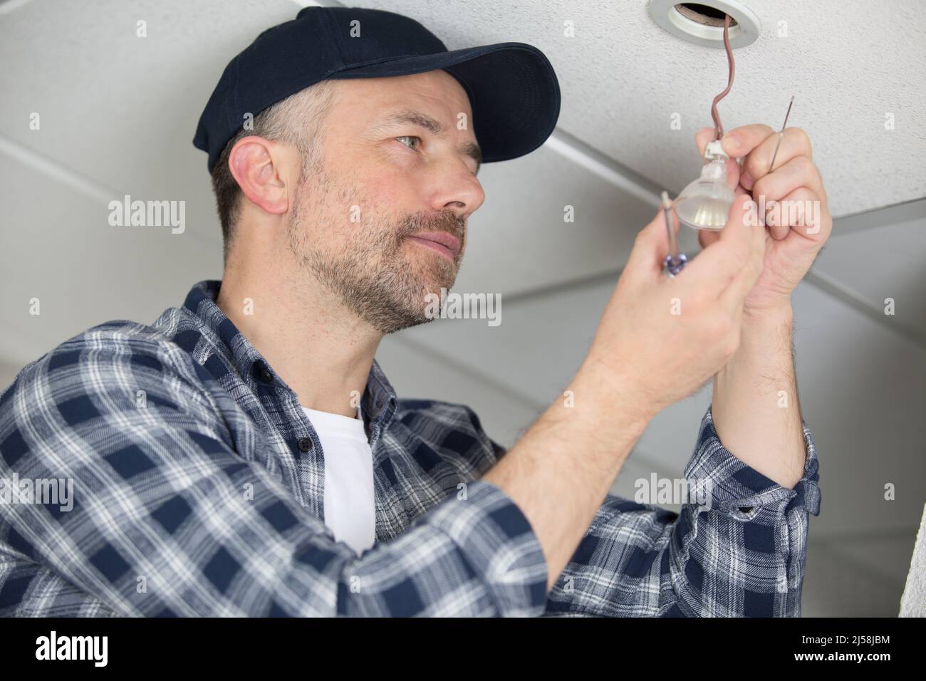 electrical man is wiring a room Stock Photo - Alamy