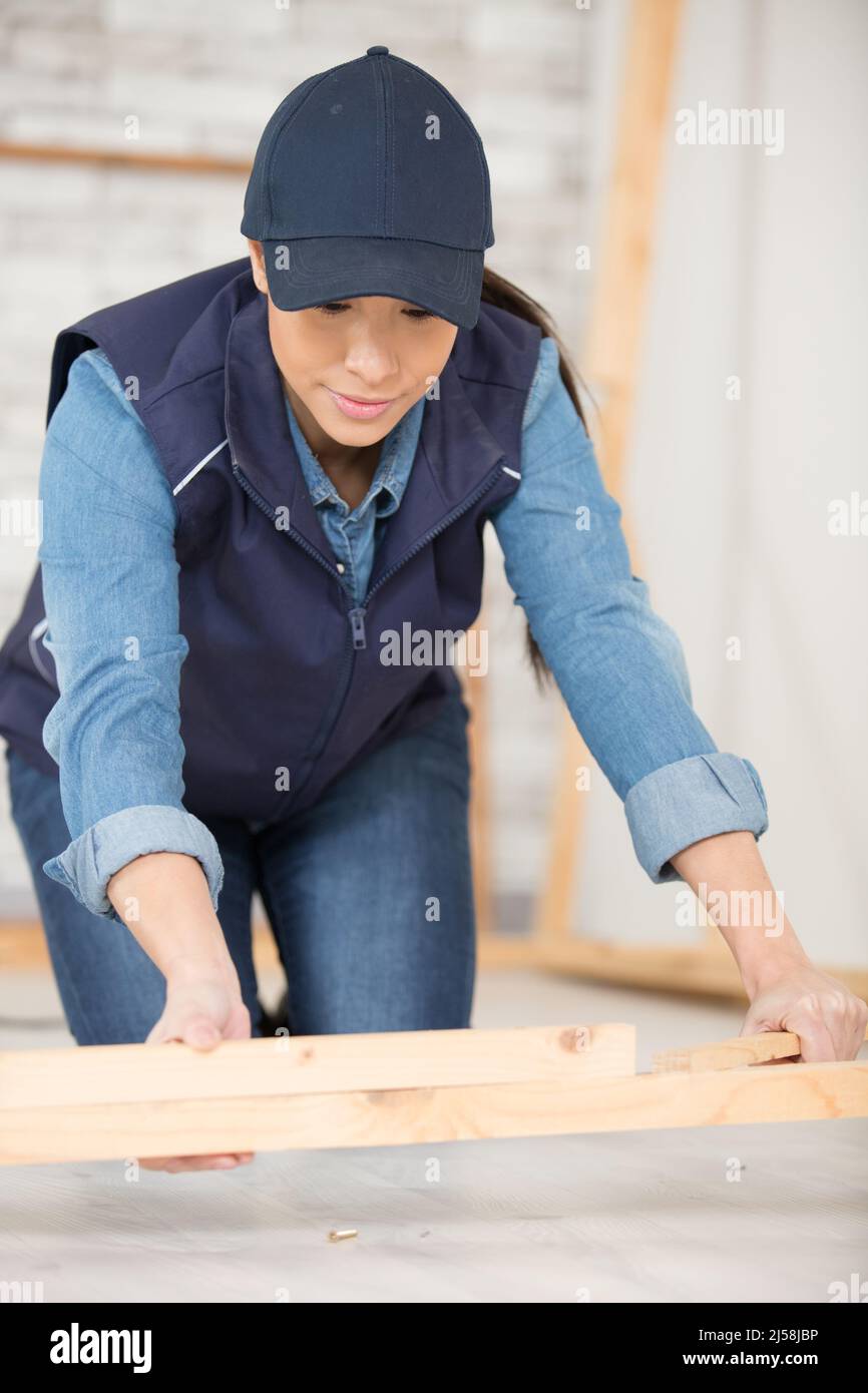 woman kneeling on the floor assembling wood Stock Photo - Alamy