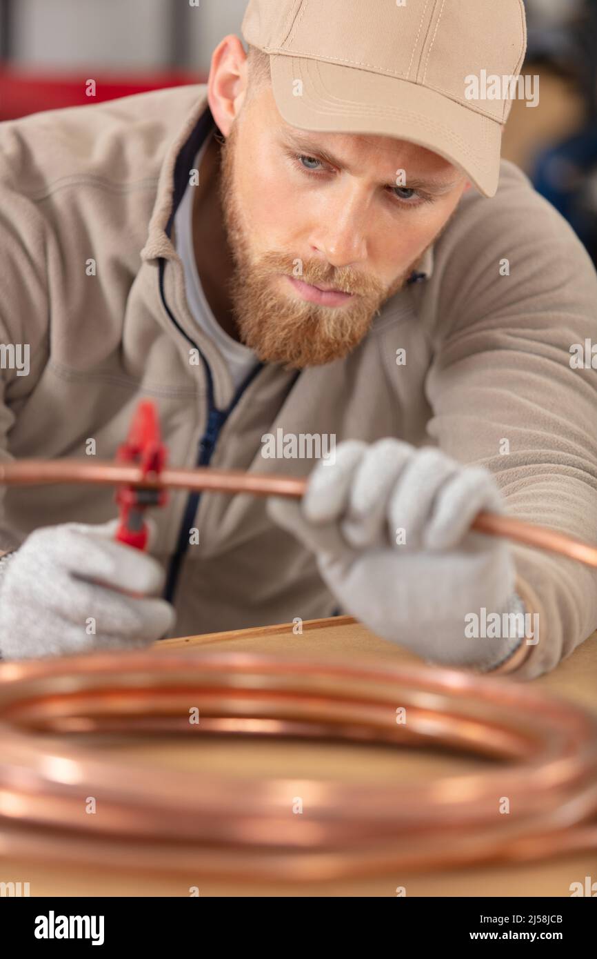 craftsman cutting a copper pipe Stock Photo - Alamy