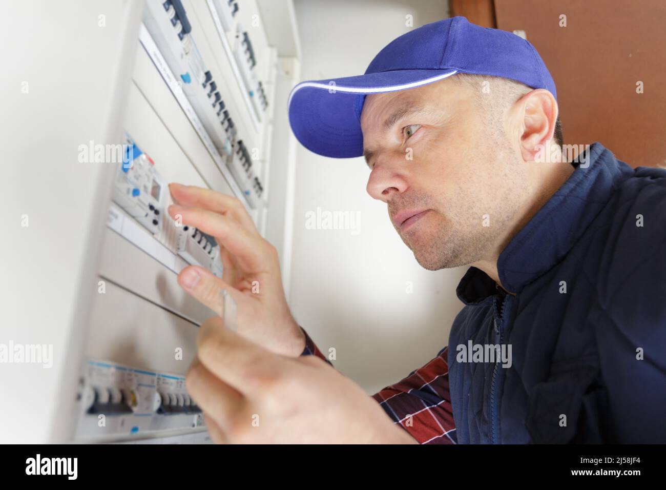 focused electrician by central fusebox Stock Photo - Alamy
