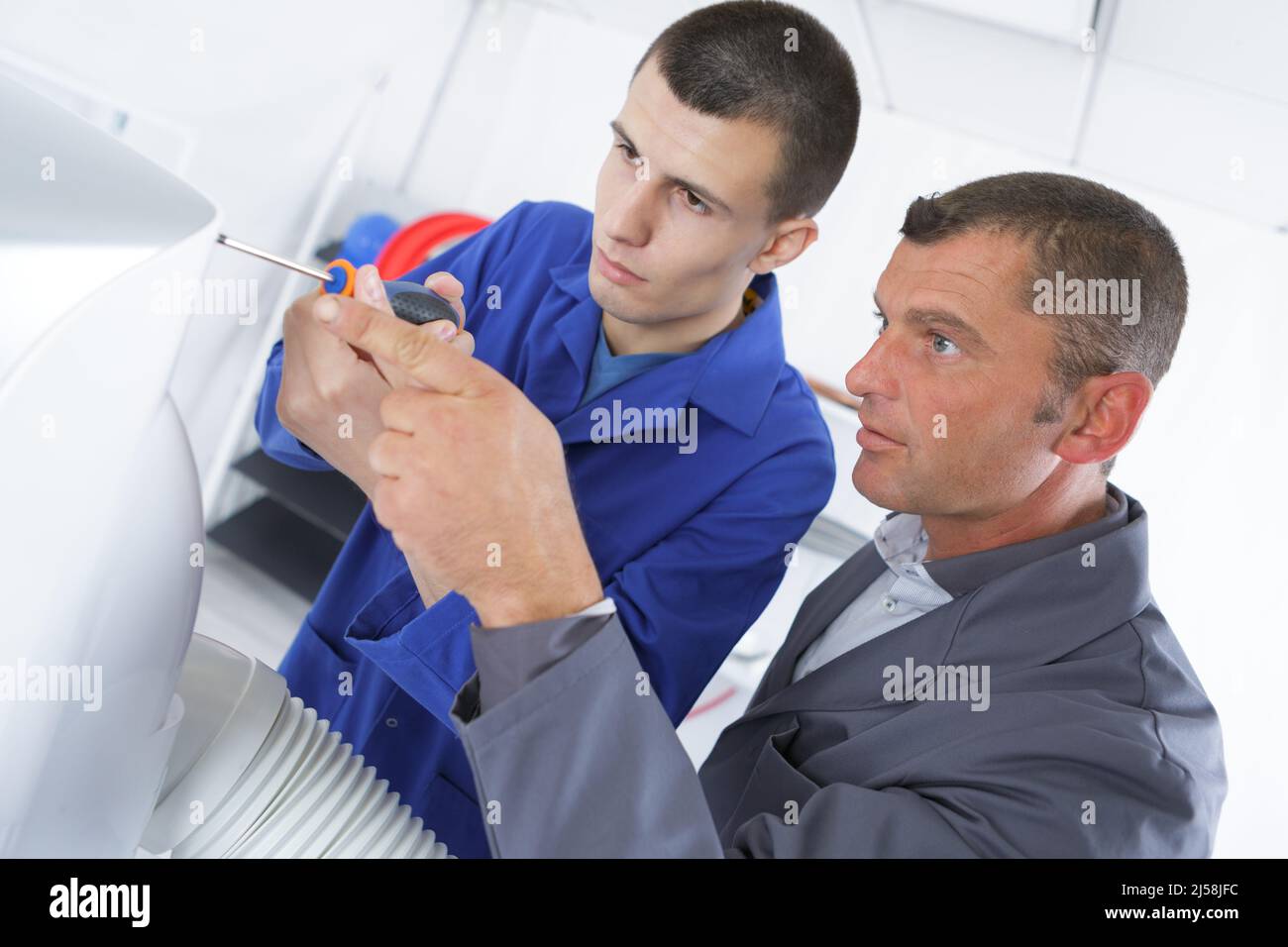 he is fixing air conditioning system Stock Photo - Alamy