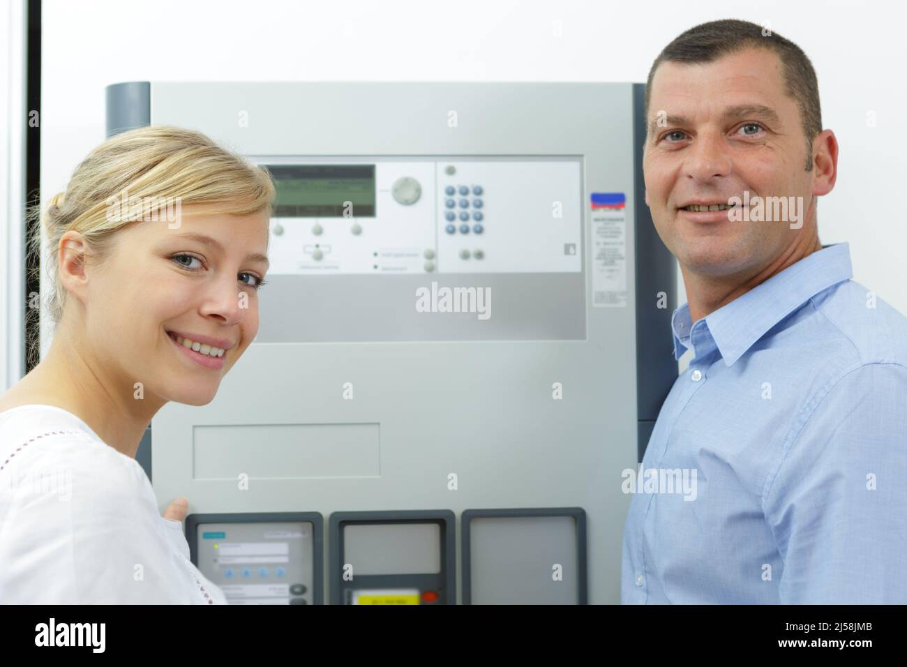 picture of two people in front of siemens machine Stock Photo - Alamy