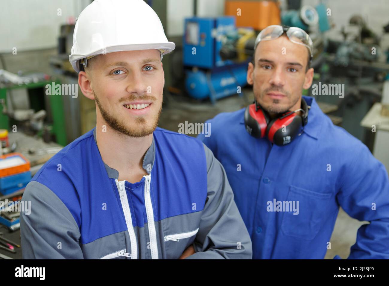 portrait of two workmen in industrial factory Stock Photo - Alamy