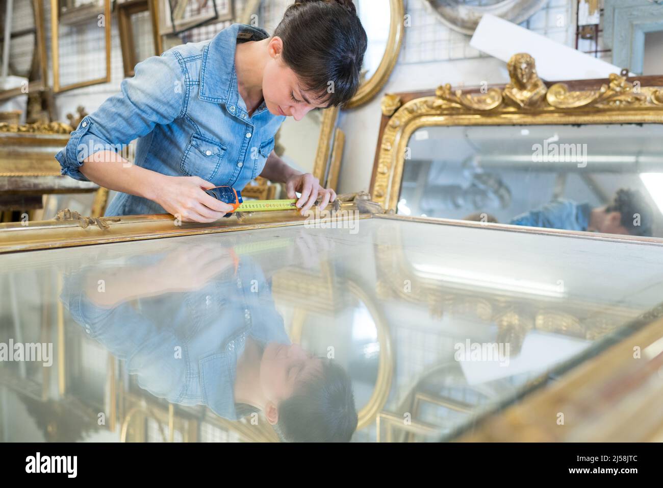 woman measuring a large antique mirror Stock Photo - Alamy
