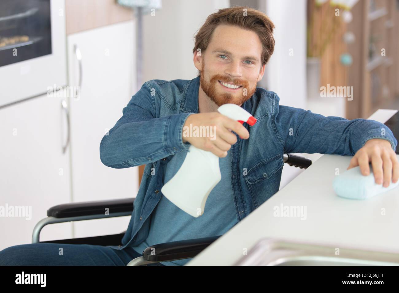 handicapped man sitting on wheelchair cleaning the kitchen Stock Photo ...