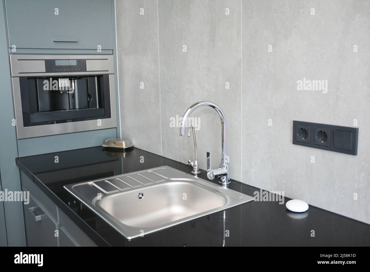 Modern kitchen with faucet and metal kitchen sink, electic stove and ...