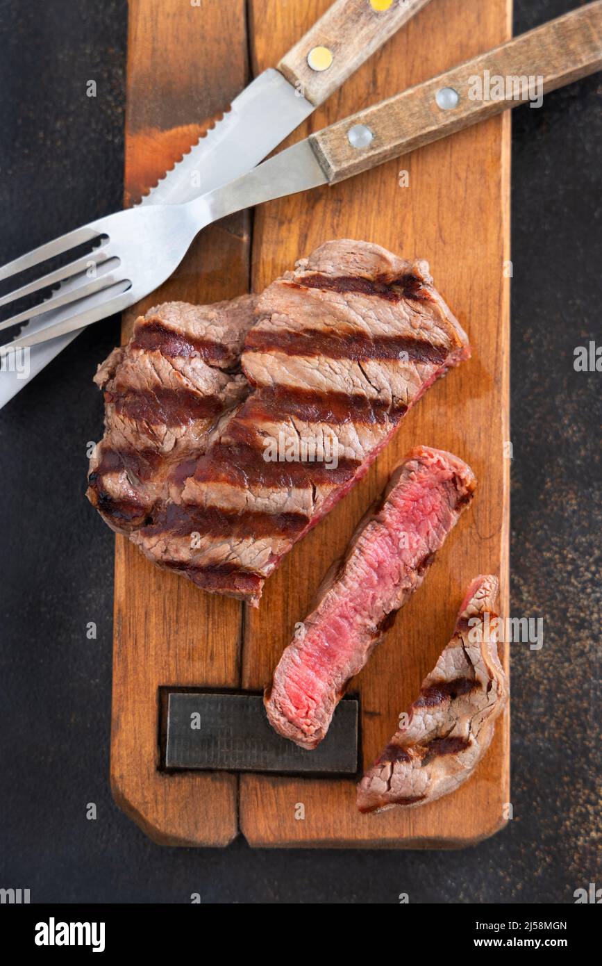 Grilled beef fillet steaks on dark table close up top view. Cooked ...