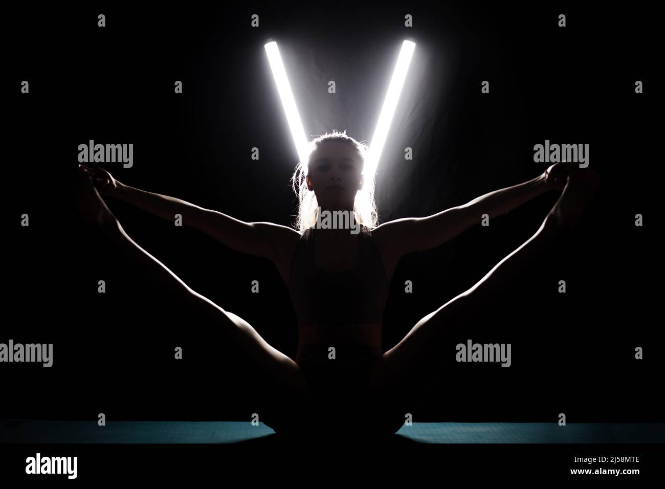 Fit woman practicing yoga poses. Silhouette girl doing exercise in ...