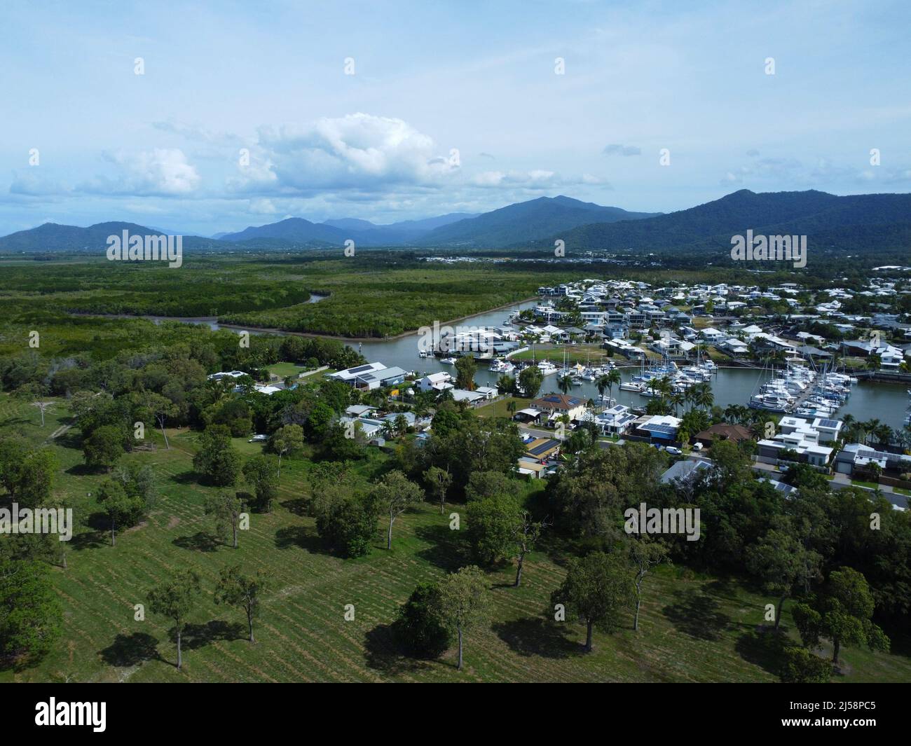 Aerial view of trinity harbour with houses and mountains and mangroves ...