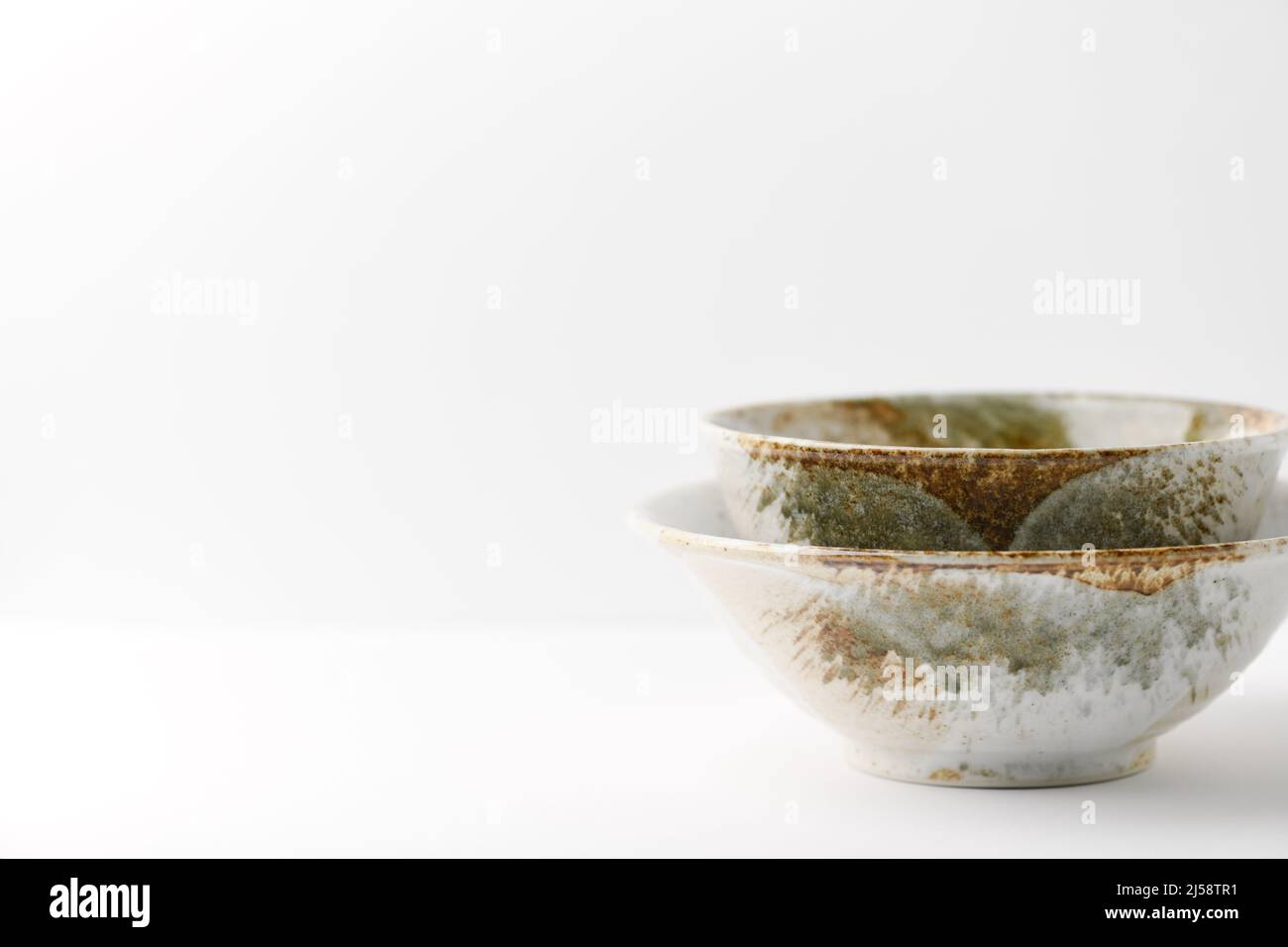 Traditional ceramic bowls on bright paper background. Soft focus. Close ...