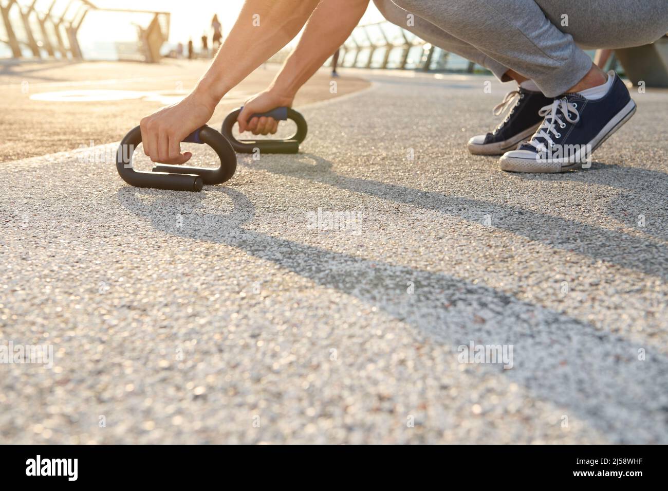 Cropped image of an athlete exercising outdoor, doing push-up exercises ...