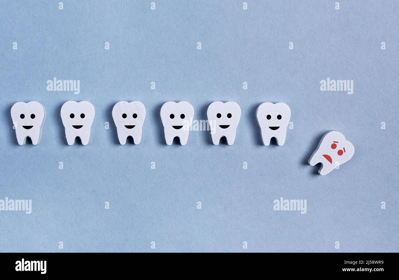 Tooth loss. Teeth row with fallen baby milk or adult one on blue ...