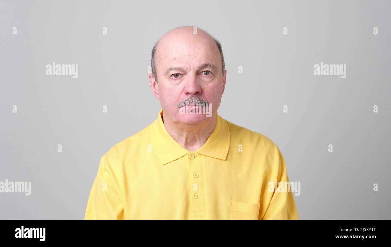 Senior hispanic man with mustache looking at camera without emotions ...