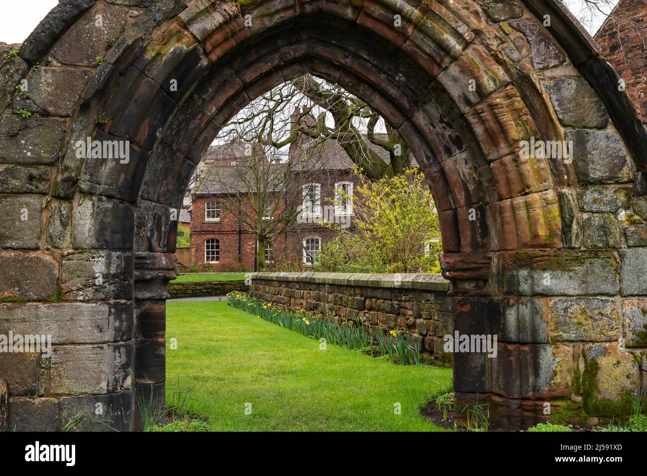 Stone archway with brick buildings in the background Stock Photo - Alamy