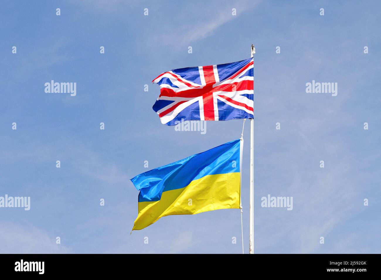 A Ukrainian and British Union Jack flag flying on the same flag pole ...