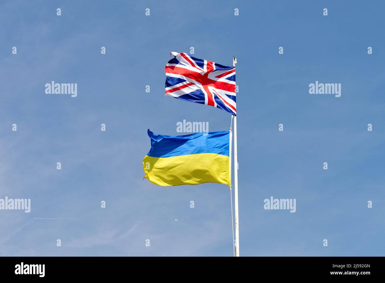 A Ukrainian and British Union Jack flag flying on the same flag pole ...