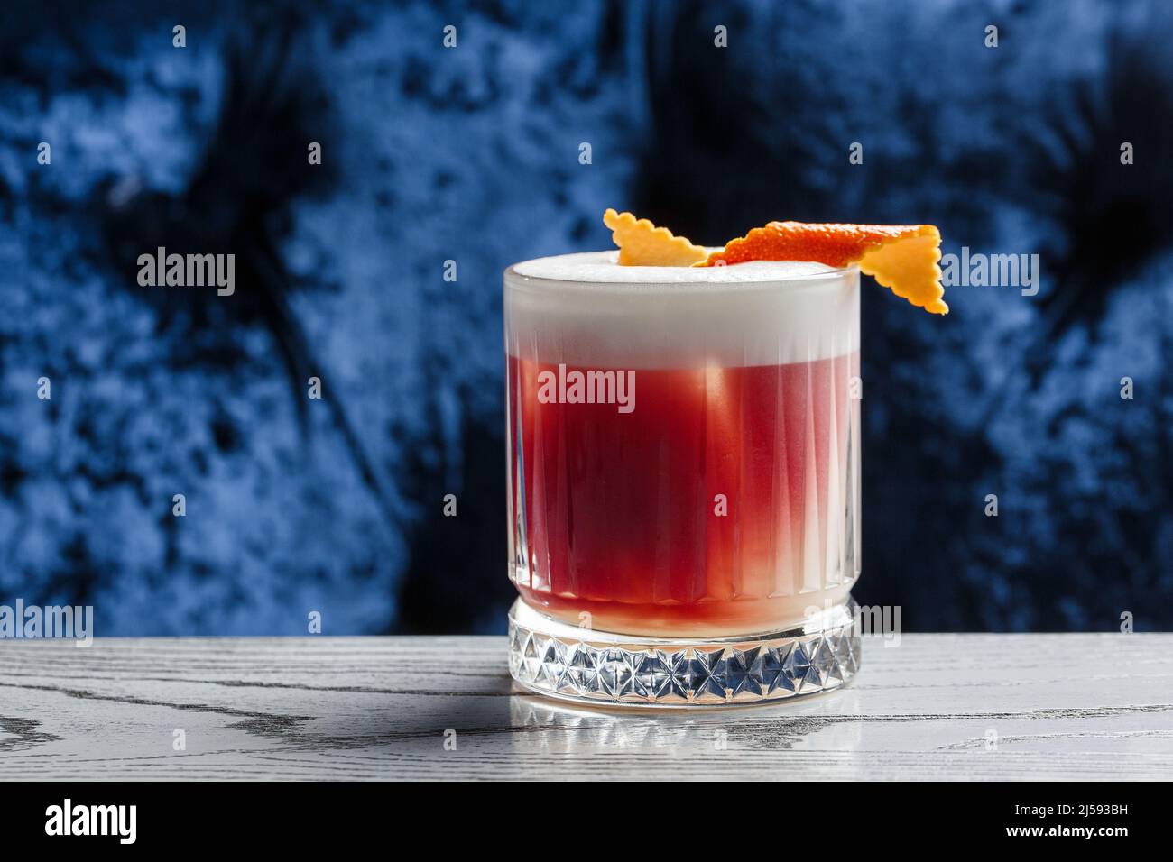 Classic old fashioned red Cocktail in a retro glass with ice and orange ...