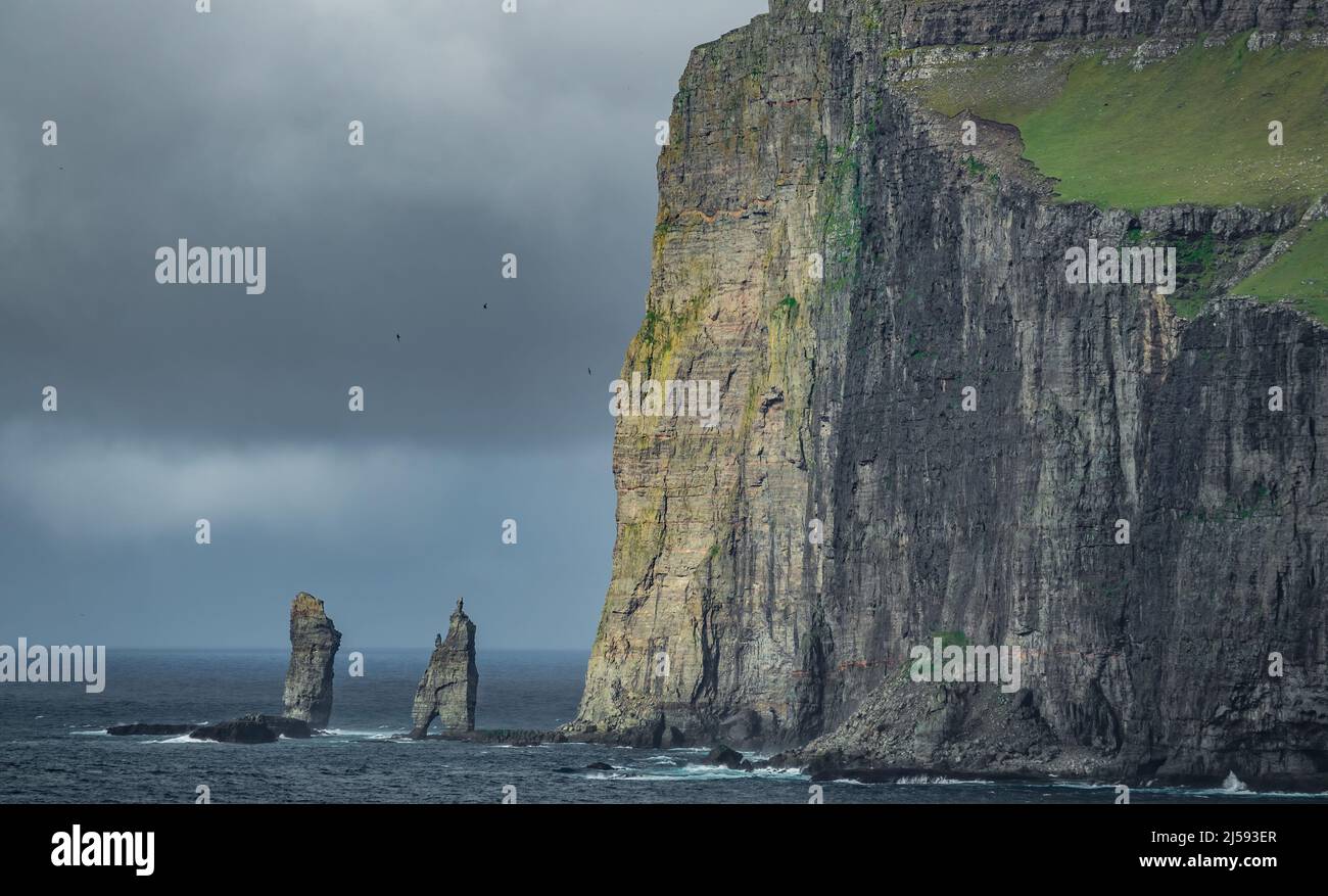Risin og Kellingin of faroe islands in the horizon under cloudy sky ...