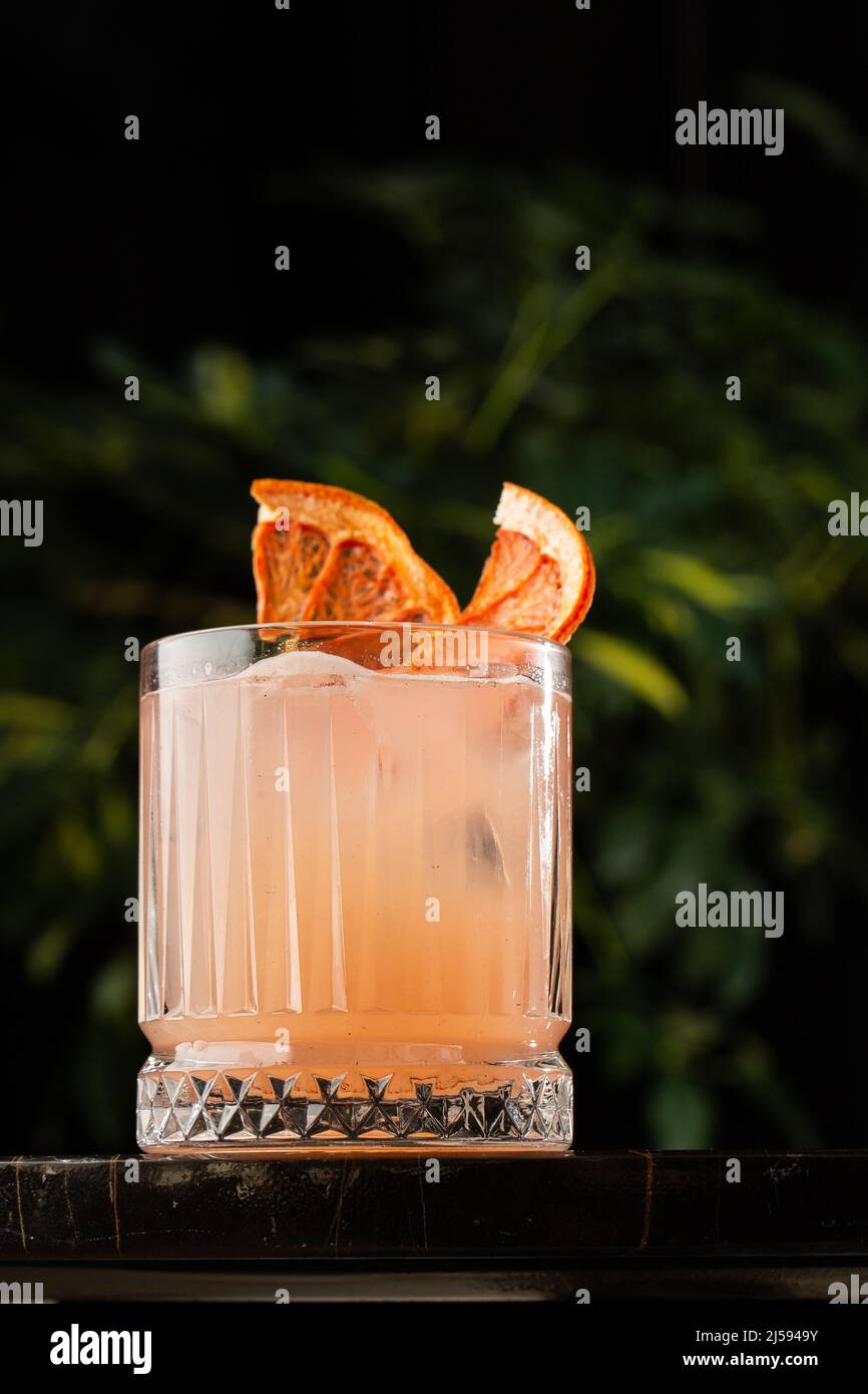 Classic orange cocktail glass on glass table in night club restaurant ...