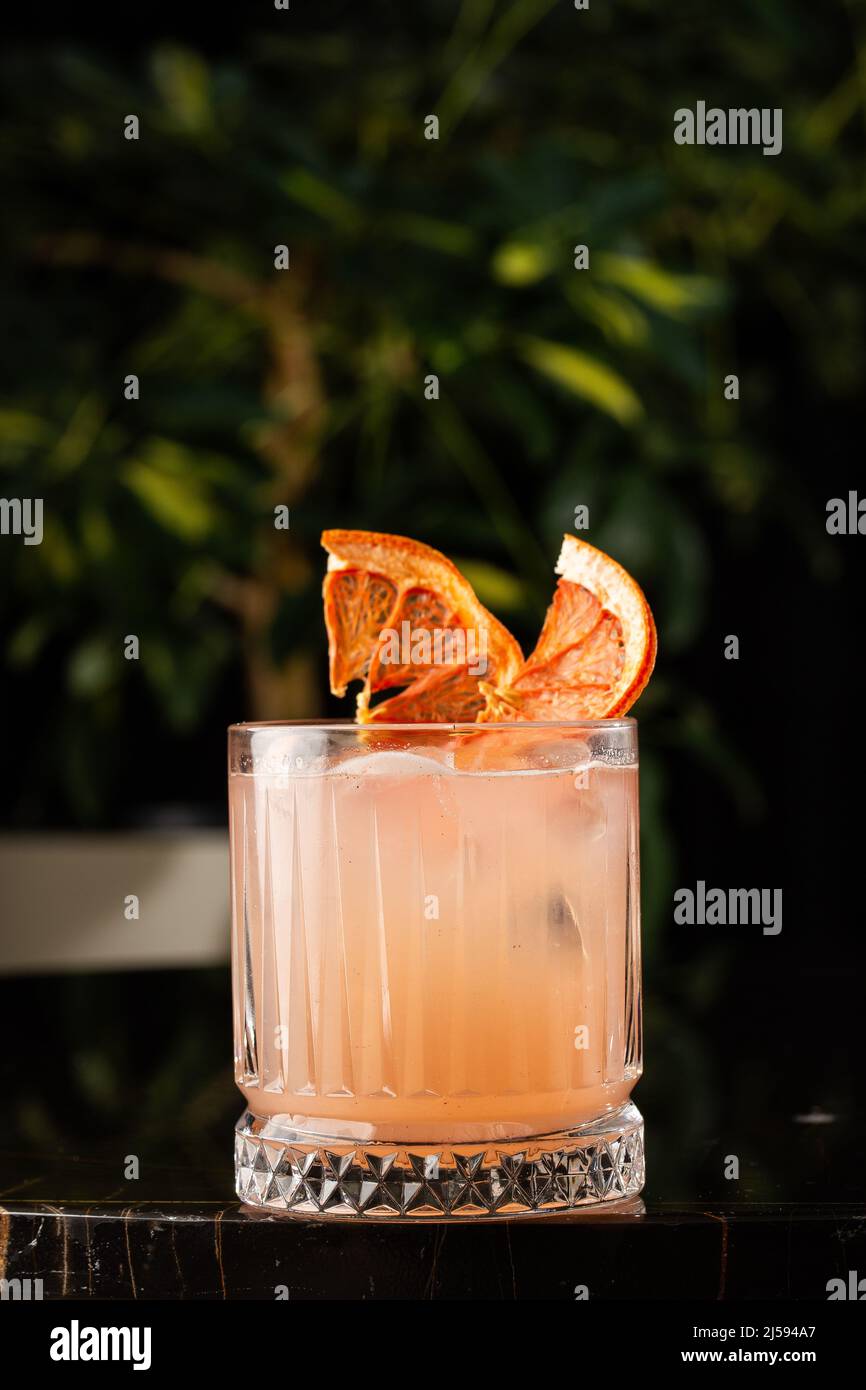 Classic orange cocktail glass on glass table in night club restaurant ...