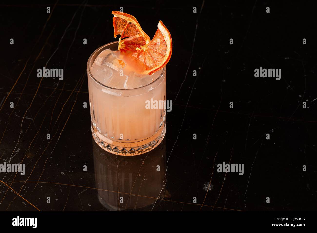 Classic orange cocktail glass on glass table in night club restaurant ...