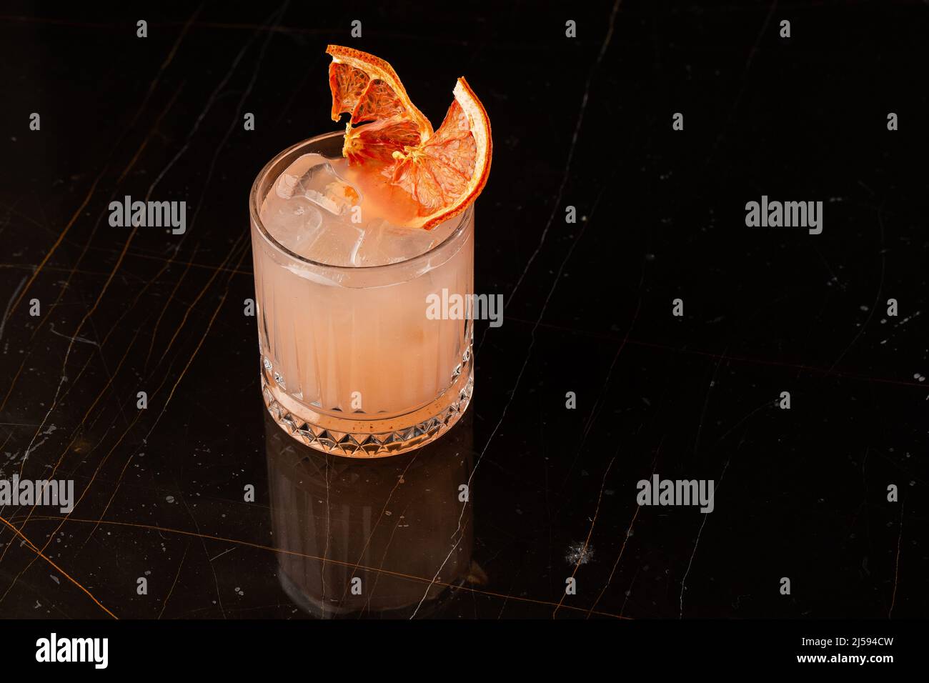Classic orange cocktail glass on glass table in night club restaurant ...