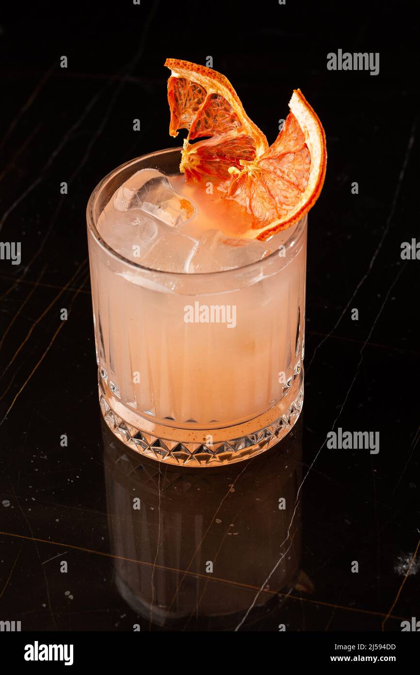 Classic orange cocktail glass on glass table in night club restaurant ...