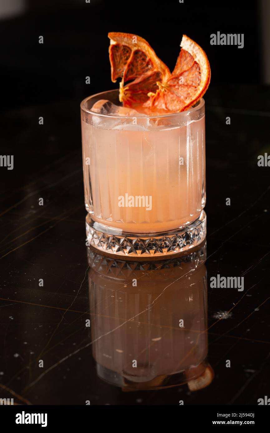 Classic orange cocktail glass on glass table in night club restaurant ...