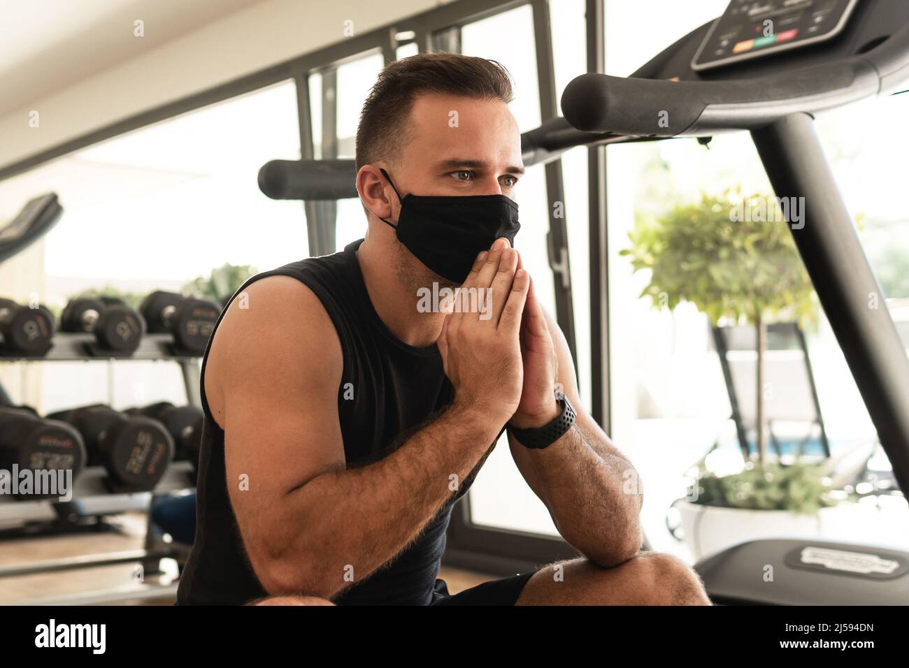 New normal concept. Young athletic man wearing a prevention face mask ...