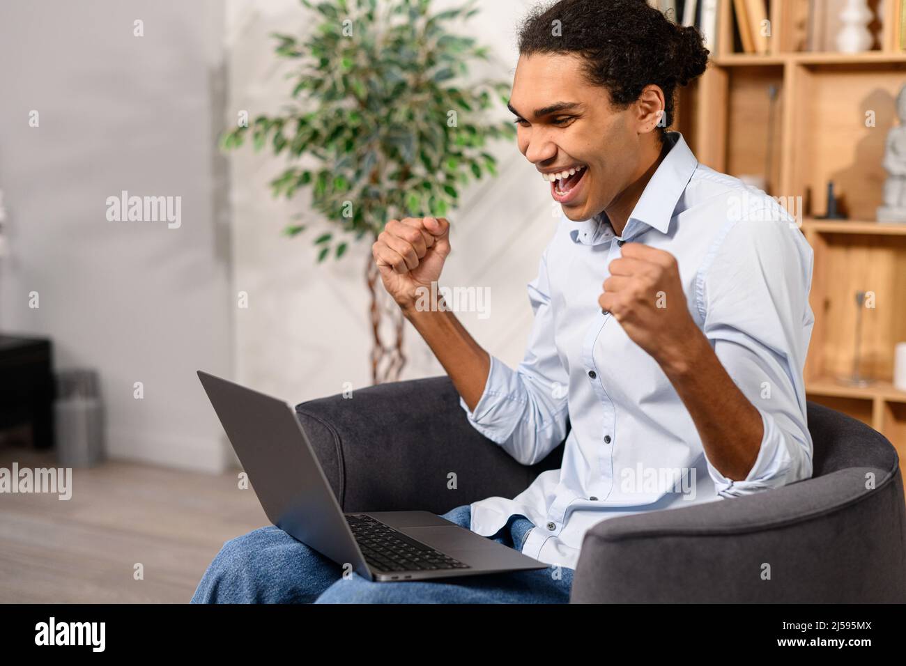 Excited businessman looking at the laptop screen and rejoicing. Happy ...