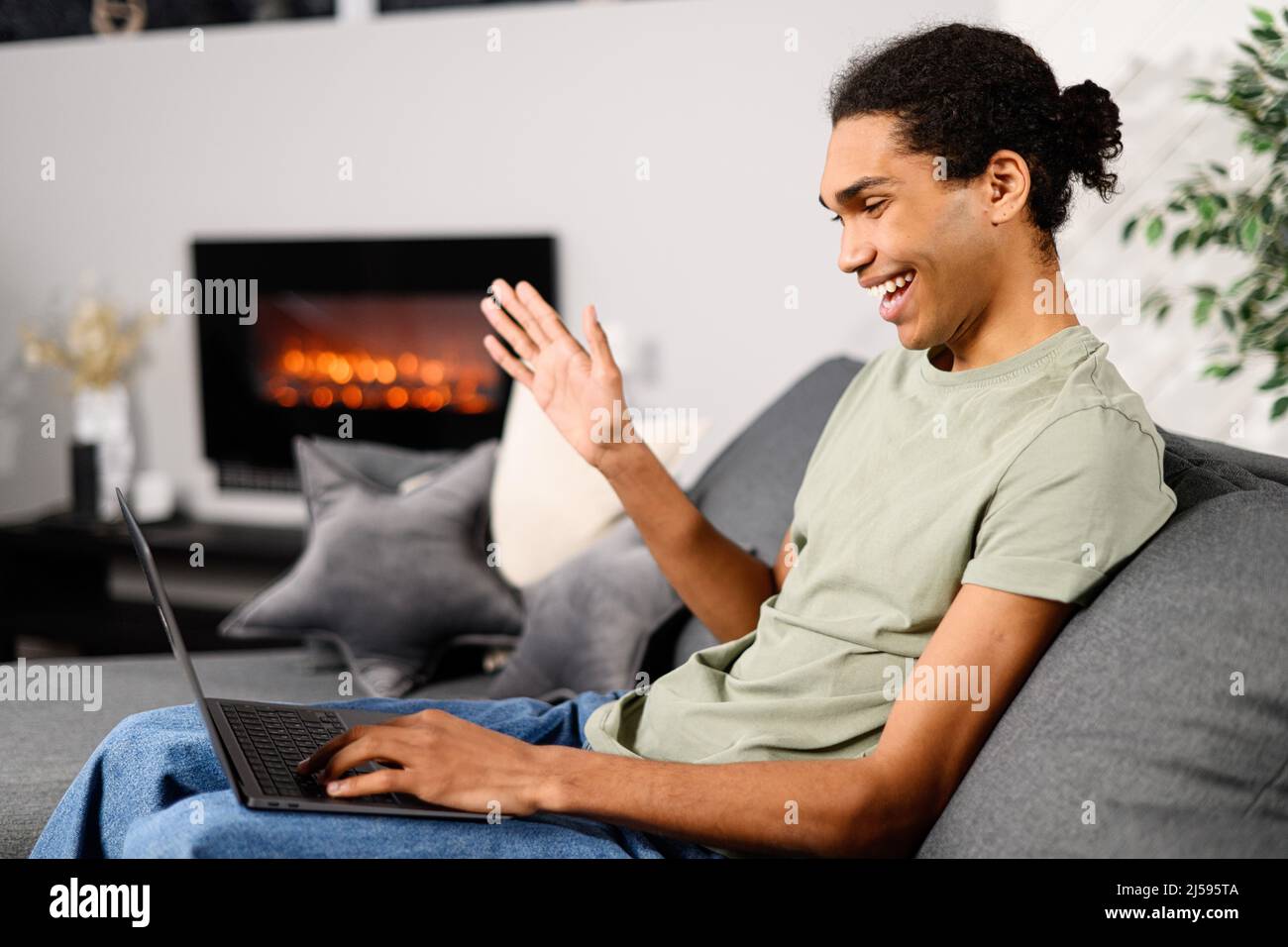Video communication, zoom. Side view of the multiracial young guy uses ...