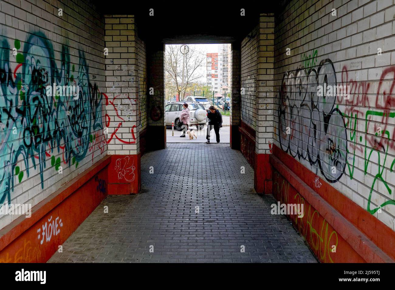 A corridor with graffiti on the walls seen on a warm spring day in ...