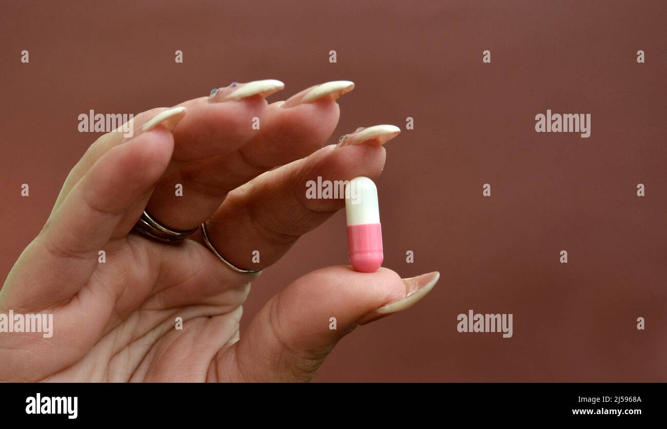 female hand holds in fingers medicine pill ,capsule Stock Photo - Alamy
