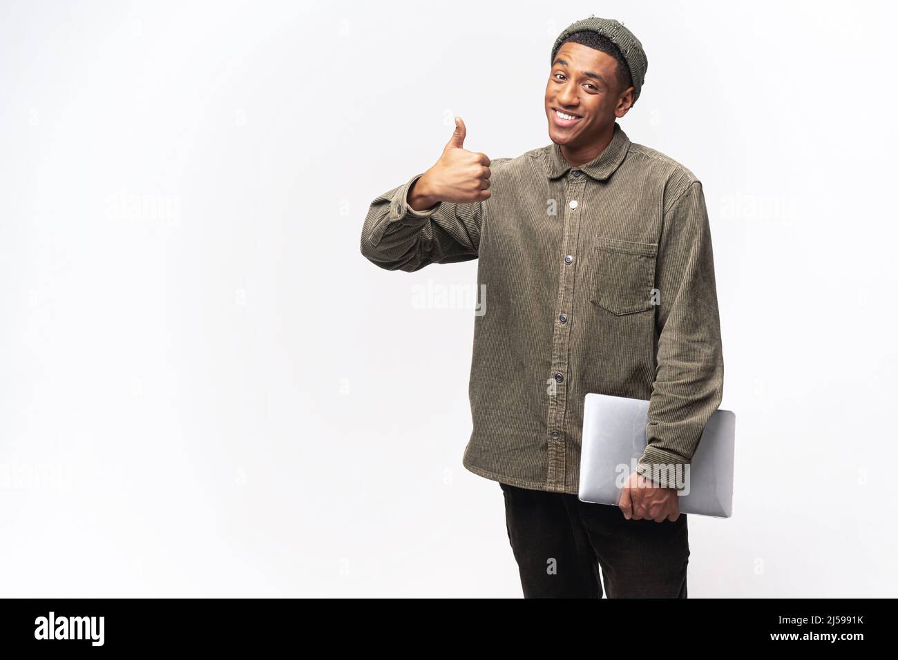 Overjoyed excited man showing big finger and holding laptop while ...
