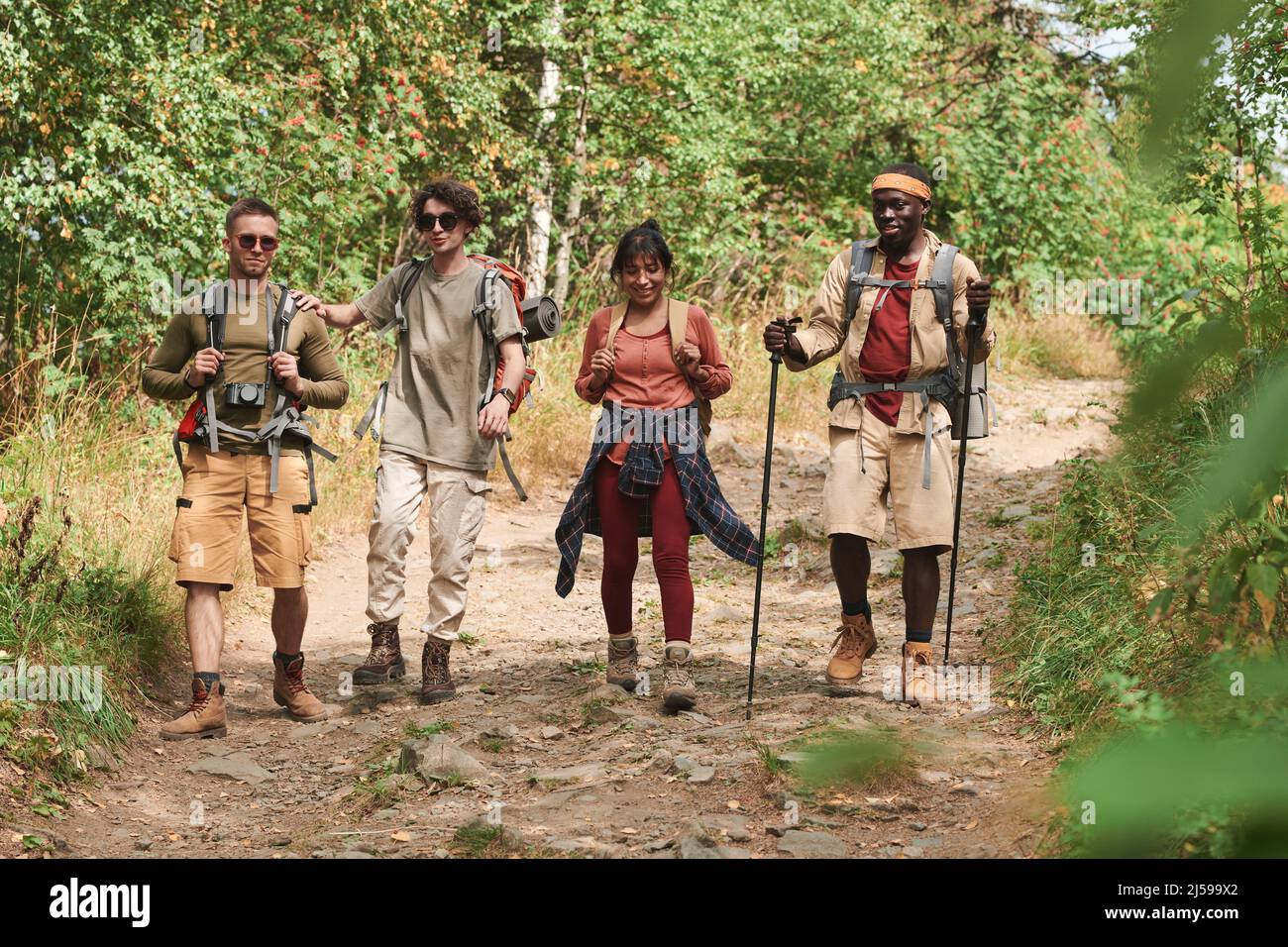 Group of young multi-ethnic friends in casual outfits carrying ...
