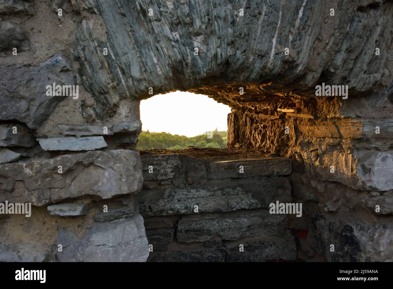 Embrasure of an old fortress with a hole in perspective in a thick wall ...