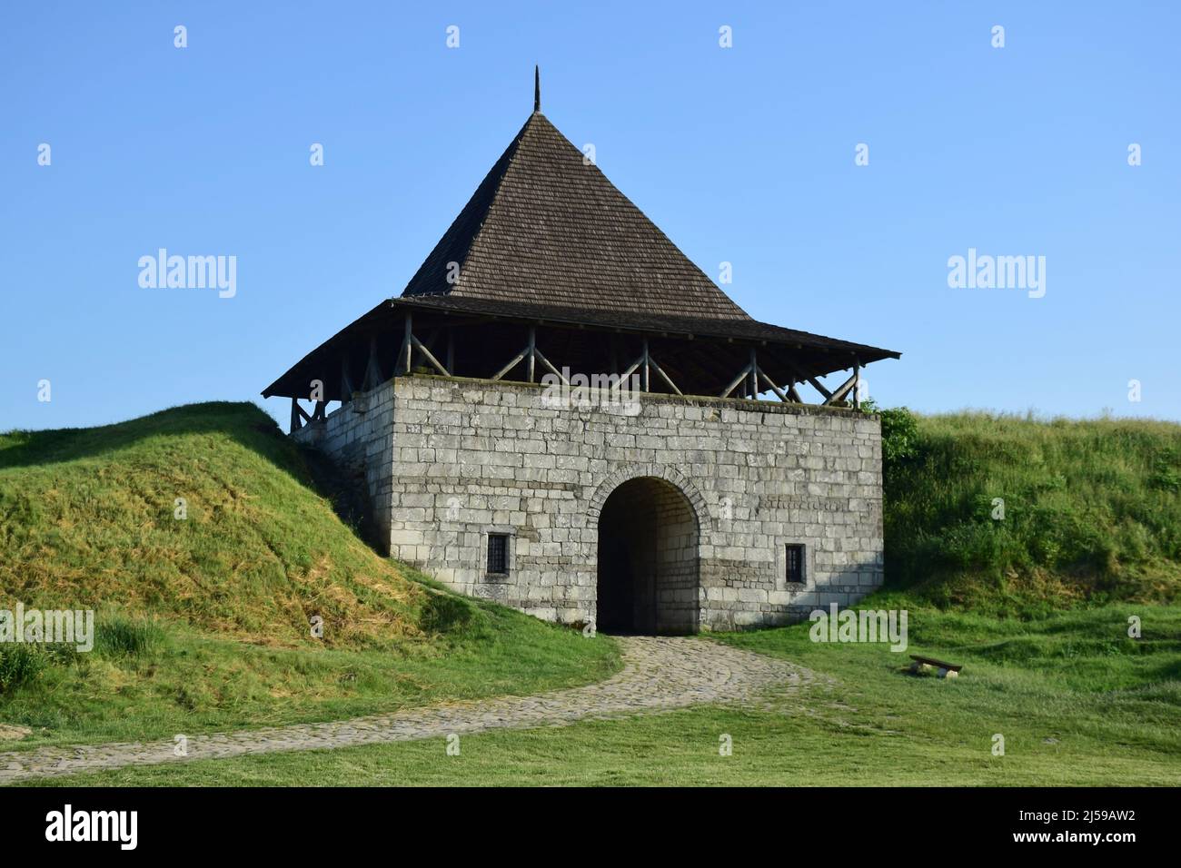 A large tower of a medieval stone fortress with an arched entrance ...