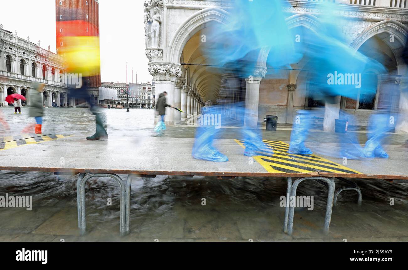People moving fast on the elevated walkway in Venice at high tide in ...