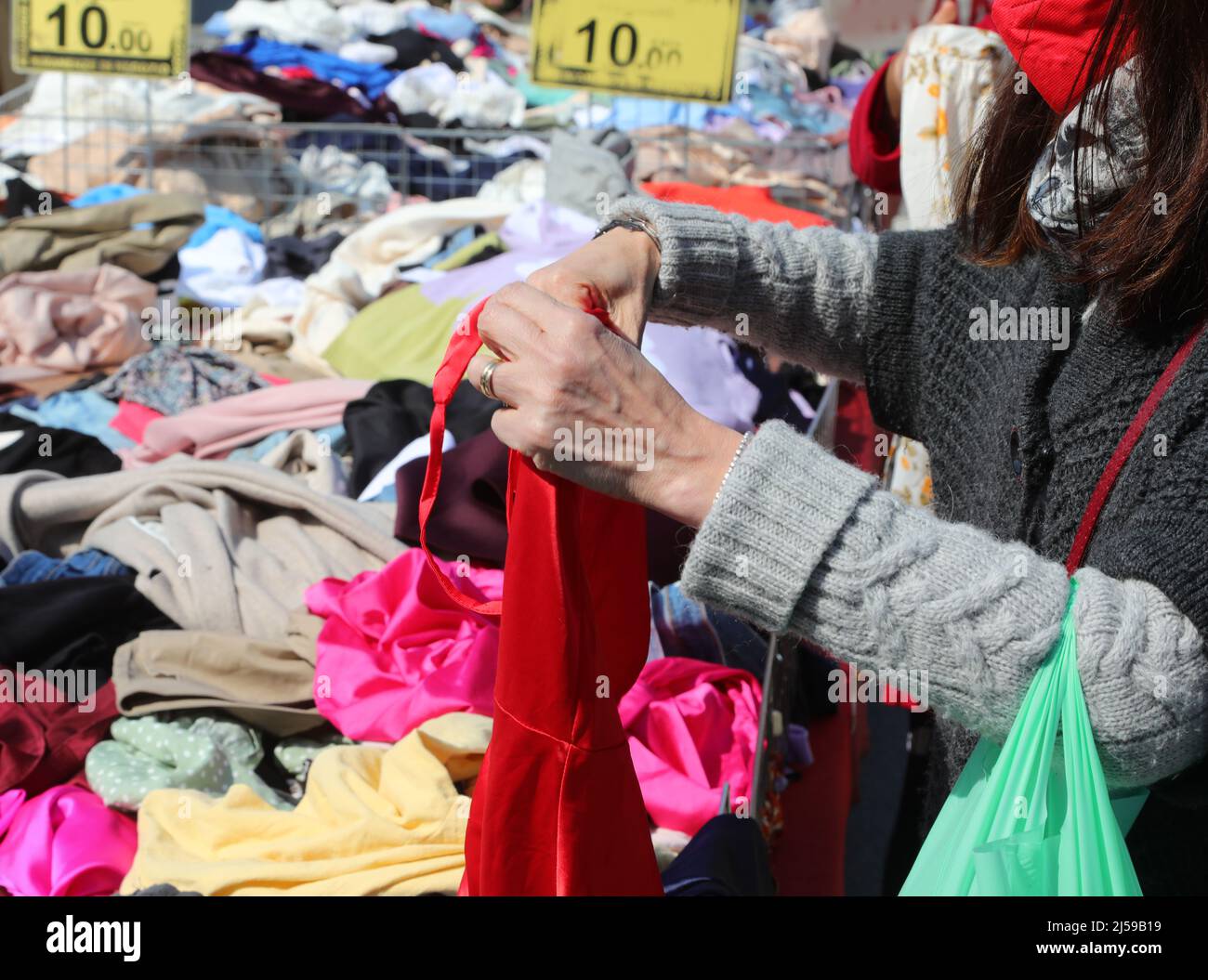 hand of girl who is choosing clothes in the used clothes stall at the ...